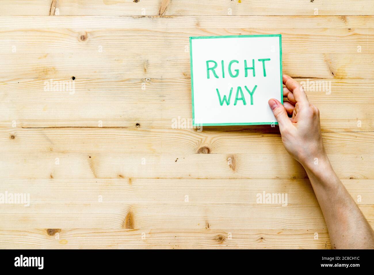 Business desicion. Right way icon in hand on wooden desk top view copy ...