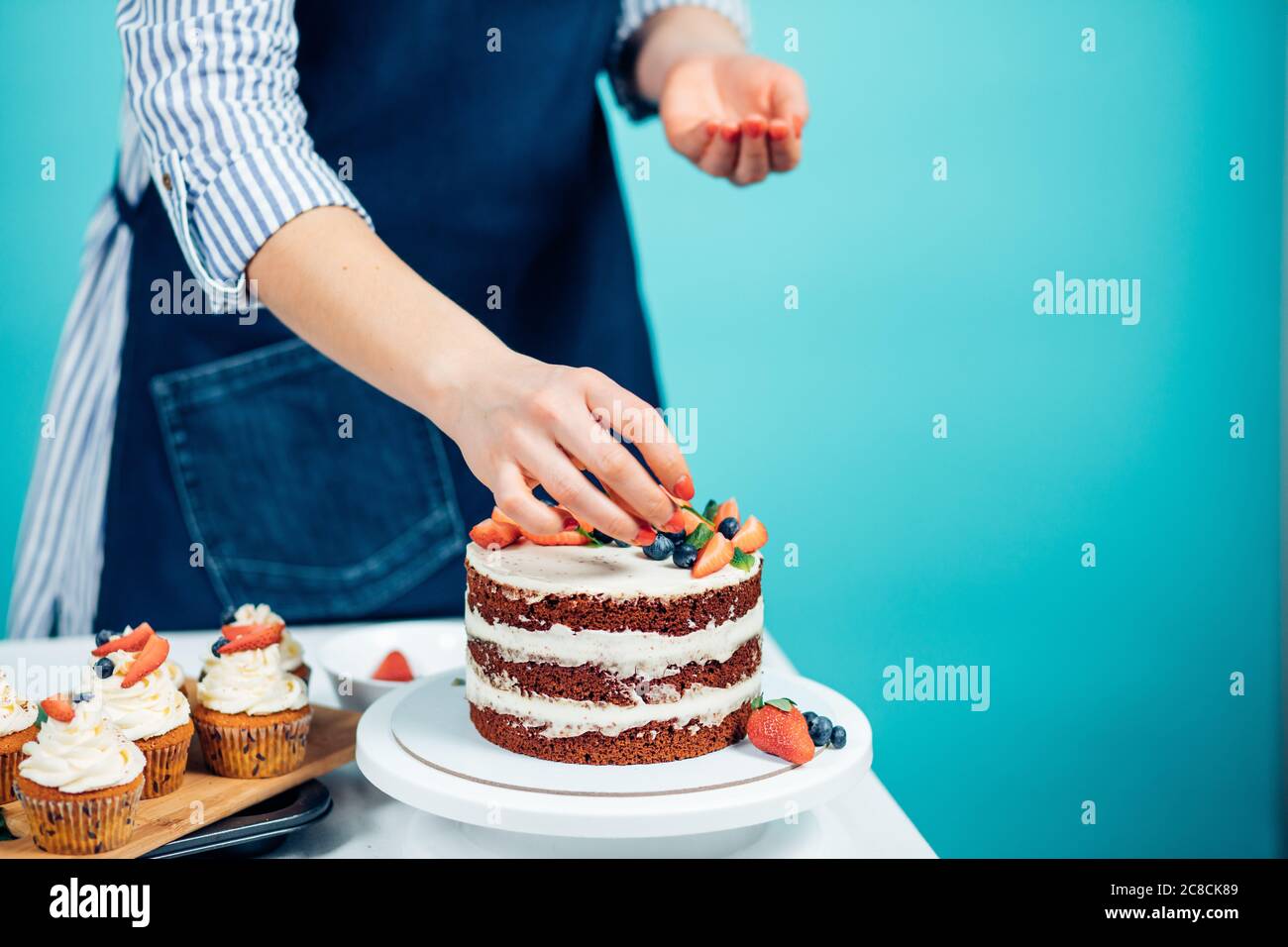 Confectioner putting on red cake hi-res stock photography and images ...