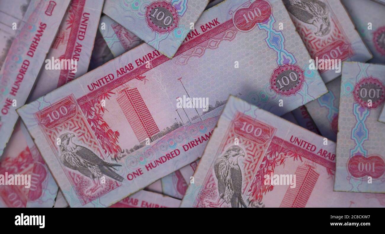 A close-up view of a scattered pile of UAE dirham banknotes - 3D render ...