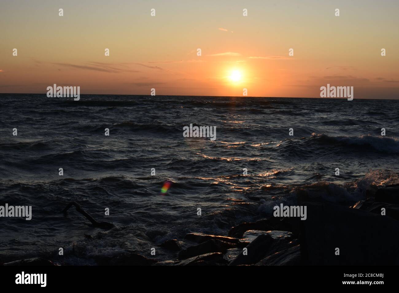 Sun setting on the water Stock Photo - Alamy