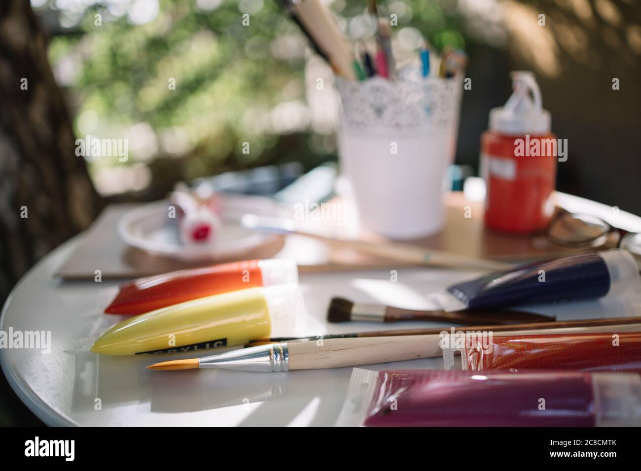 Paint tubes and paint brushes on white table Stock Photo - Alamy