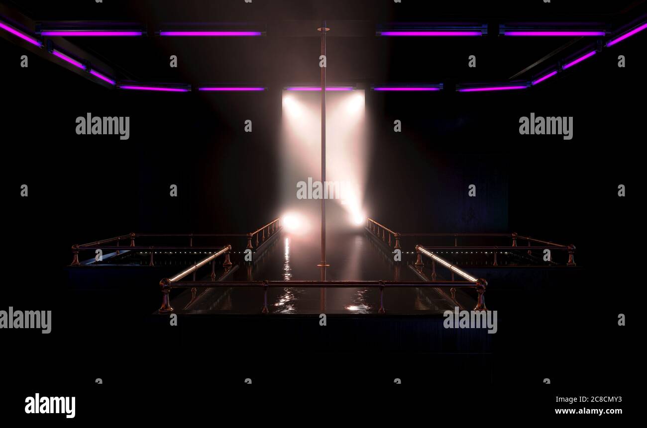 An empty strip club dancing stage with a pole and brass railings and ...