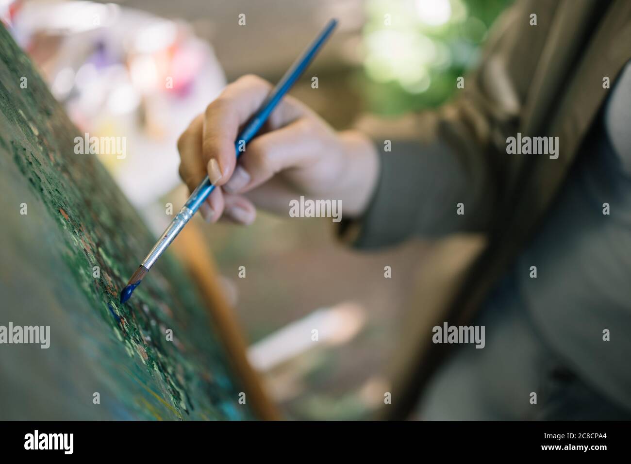Woman's hand holding brush and painting picture Stock Photo - Alamy