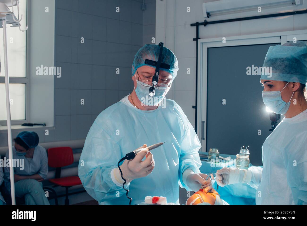 Nurse hand taking surgical instrument for group of surgeons at ...