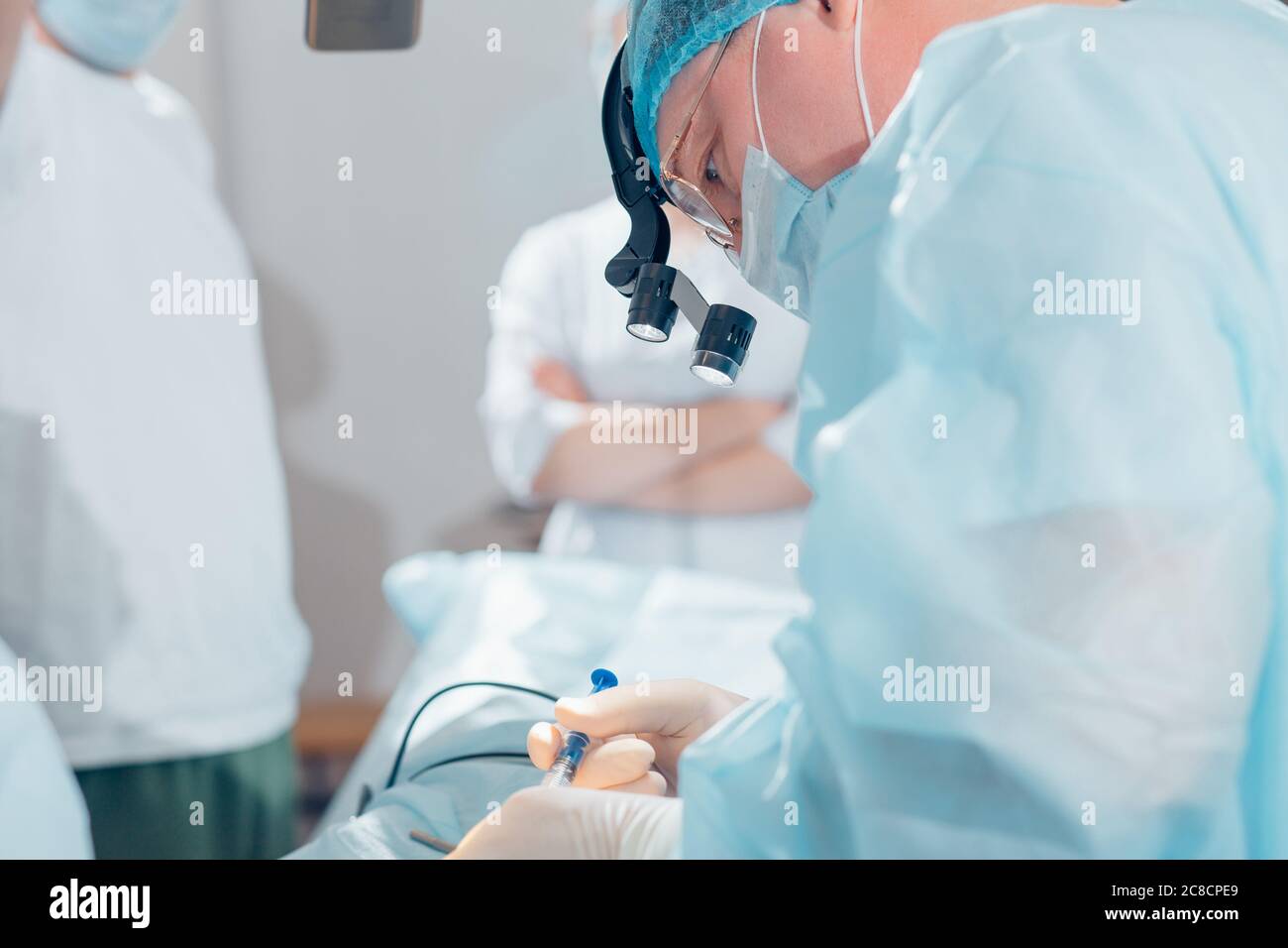 Surgeon performing cosmetic surgery on nose in hospital operating room ...