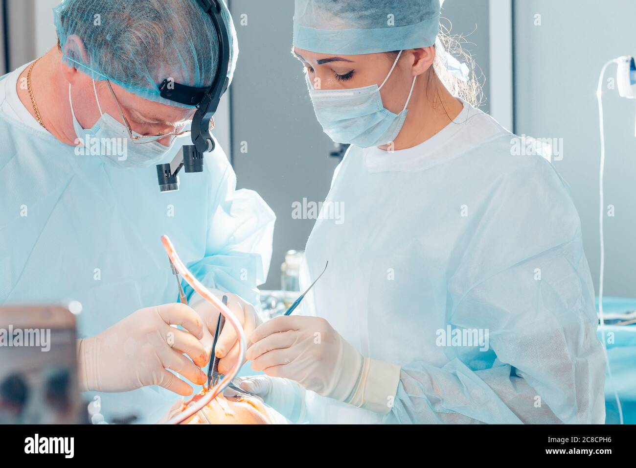 Team of surgeon in uniform perform operation on a patient at plastic ...