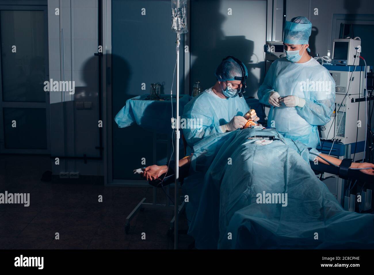 Team of surgeon in uniform perform operation on a patient at plastic ...