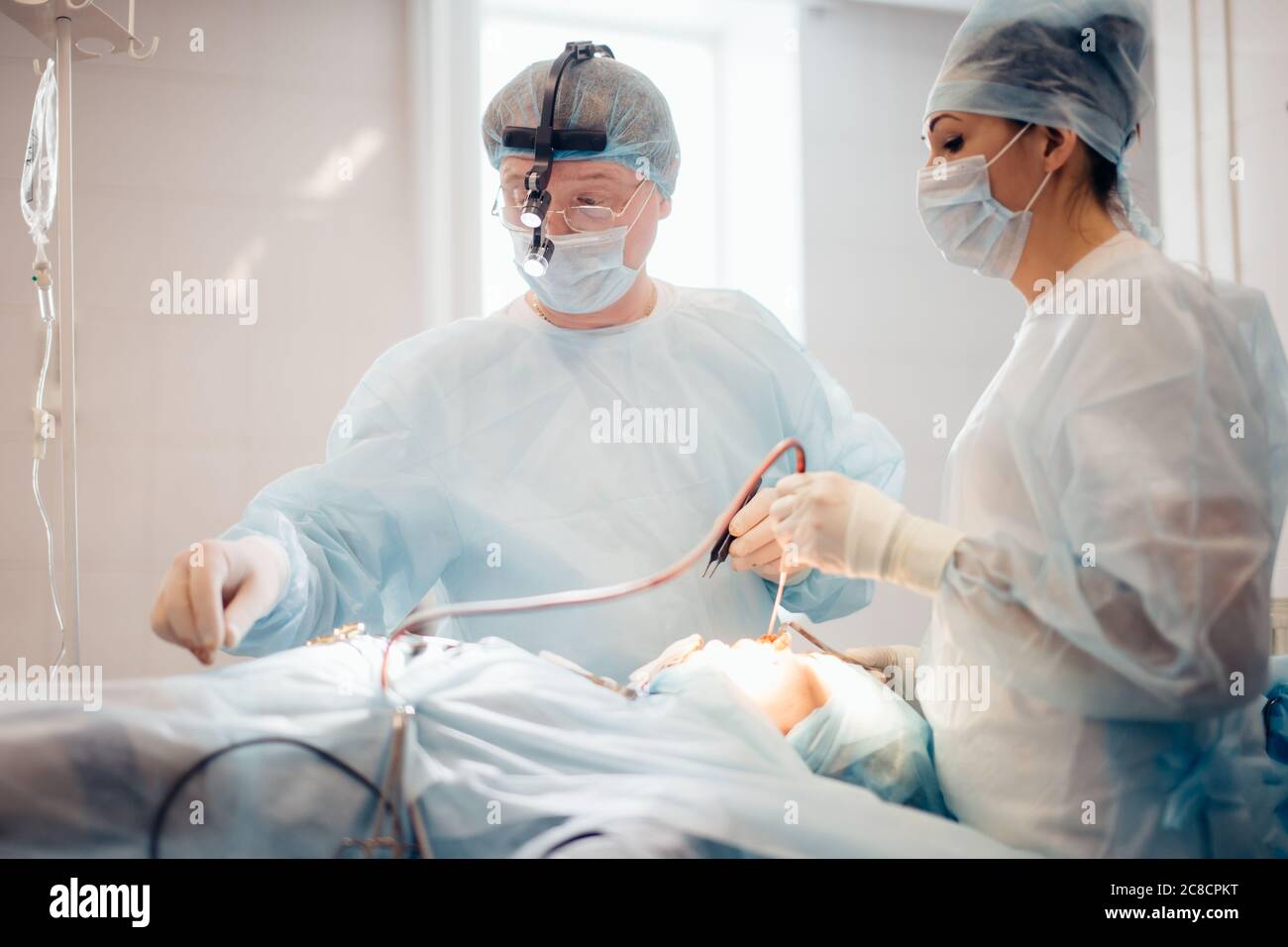 Nurse hand taking surgical instrument for group of surgeons at ...