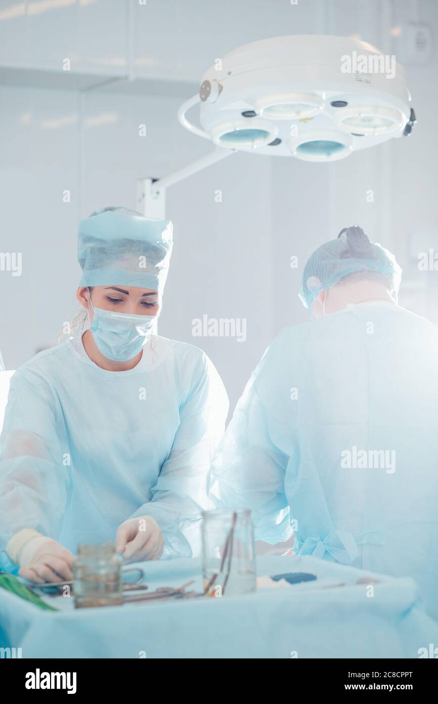 young female wearing mask surgeon doing operation Stock Photo - Alamy