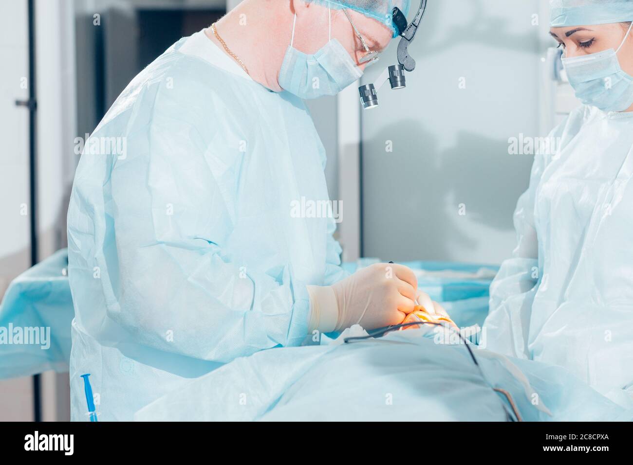 Team of surgeon in uniform perform operation on a patient at plastic ...