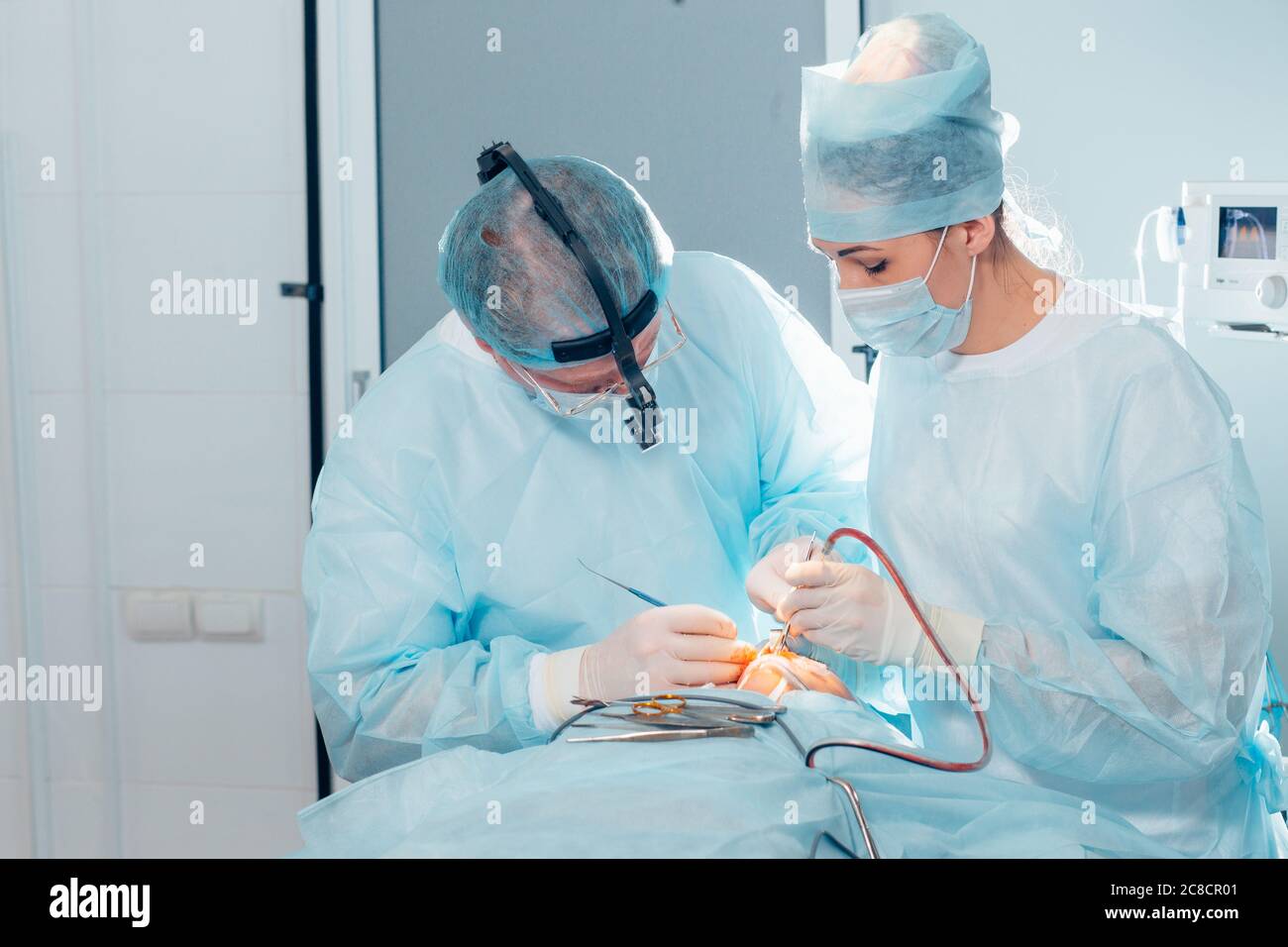 Surgeon performing cosmetic surgery on nose in hospital operating room ...