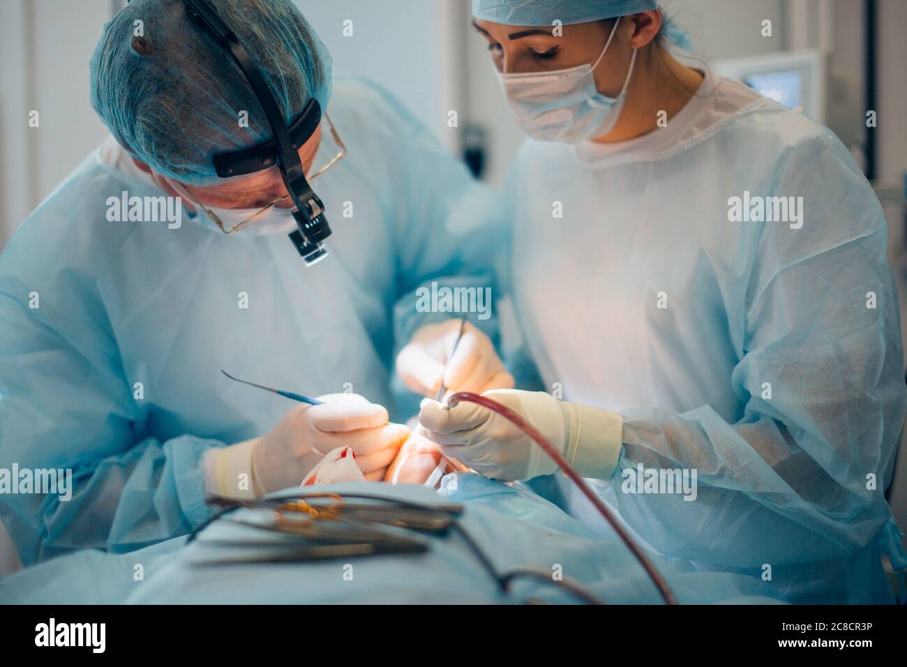 Team of surgeon in uniform perform operation on a patient at plastic ...