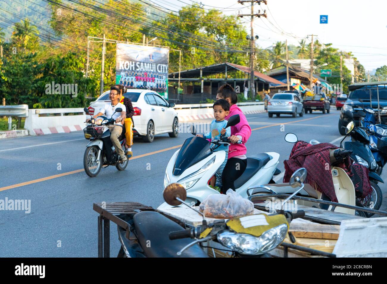 Mom with a small child without helmets rides on a motobike Stock Photo ...