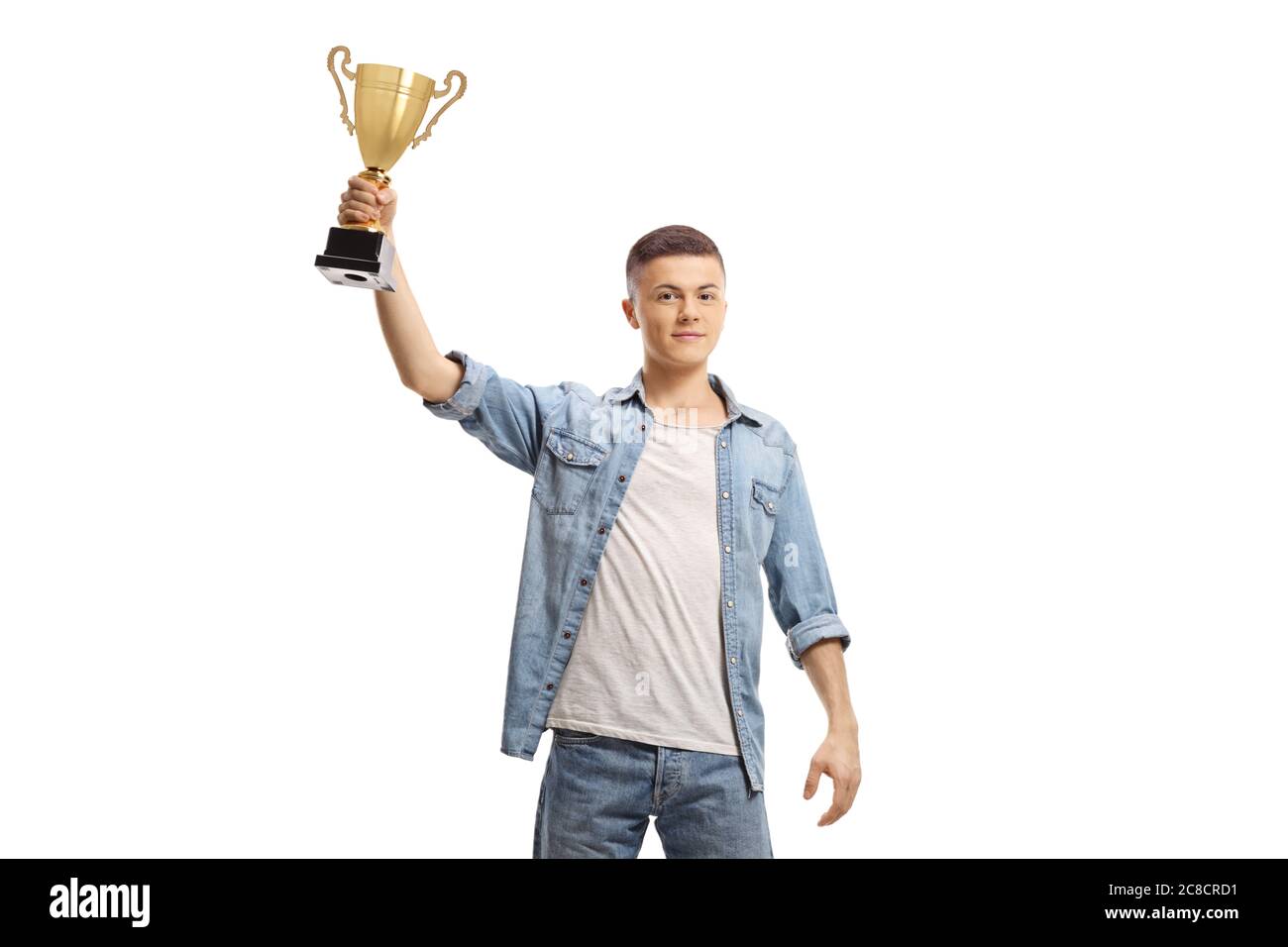 Casual guy holding a gold trophy cup up isolated on white background ...