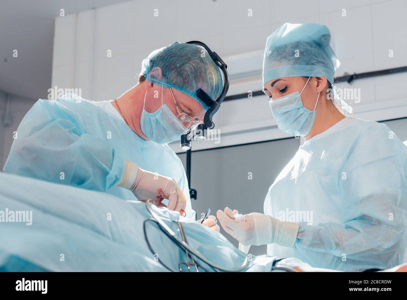 Team of surgeon in uniform perform operation on a patient at plastic ...