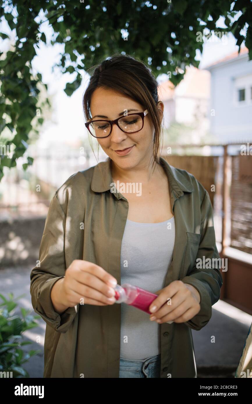 Female artist opening red acrylic paint tube Stock Photo - Alamy