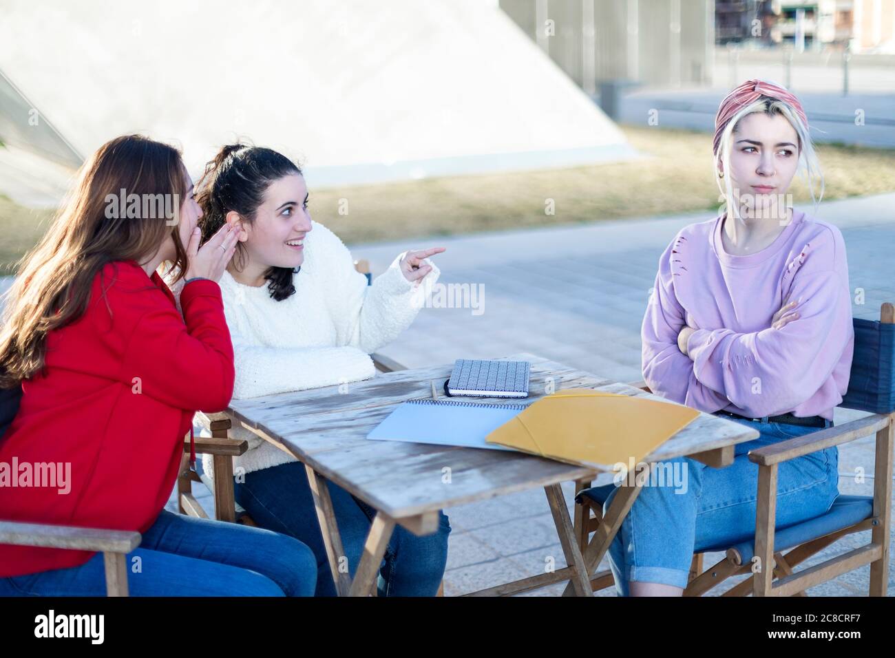 Two gossip friends criticizing another woman outdoors Stock Photo - Alamy
