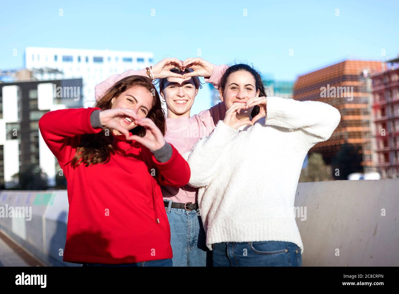three female friends making heart shape with hands Stock Photo - Alamy
