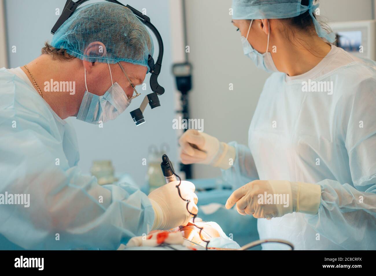 Team of surgeon in uniform perform operation on a patient at plastic ...