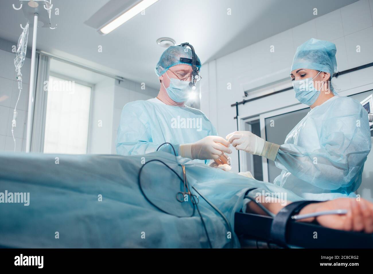 Nurse hand taking surgical instrument for group of surgeons at ...