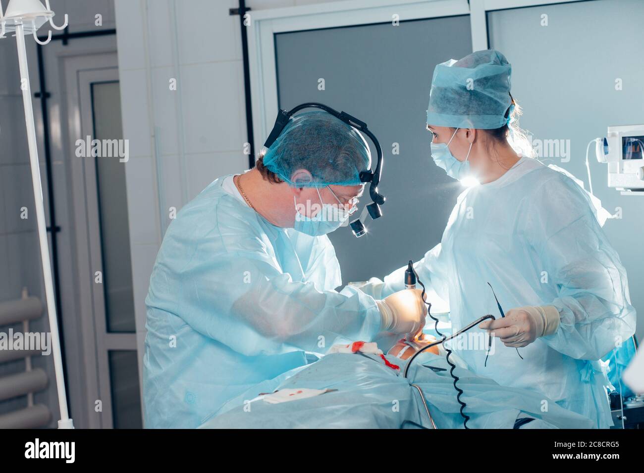 Team of surgeon in uniform perform operation on a patient at plastic ...