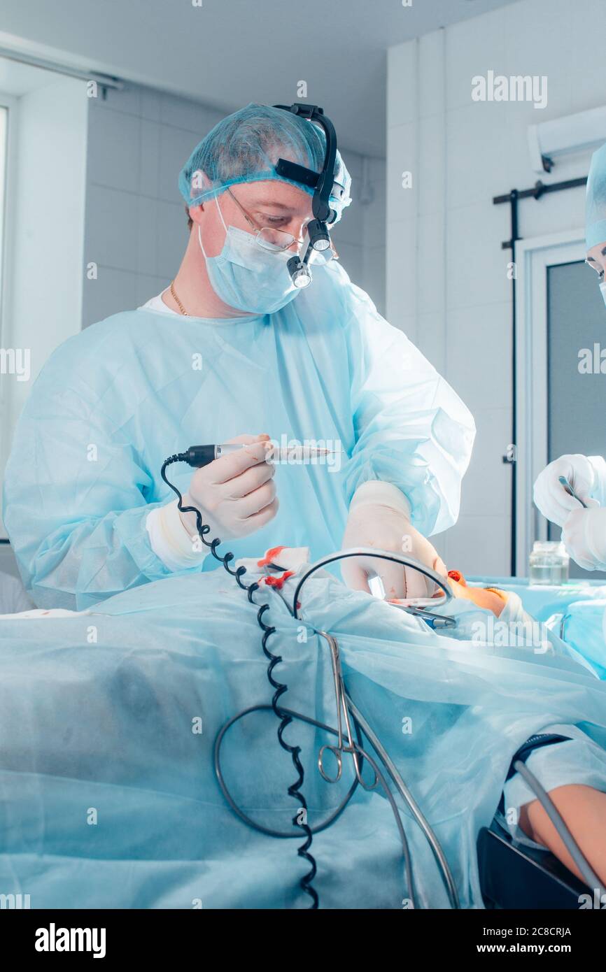 Surgeon performing cosmetic surgery on nose in hospital operating room ...