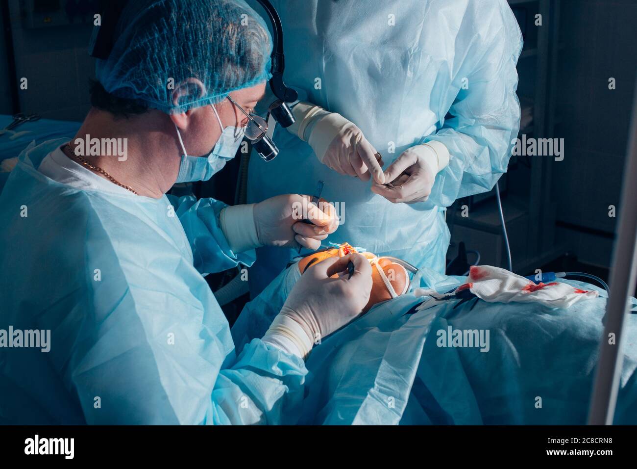 Surgeon performing cosmetic surgery on nose in hospital operating room ...