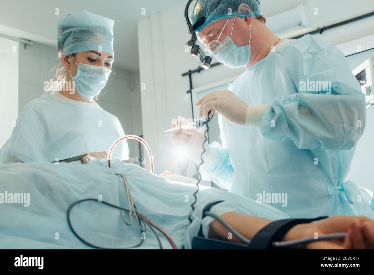 Surgeon performing cosmetic surgery on nose in hospital operating room ...