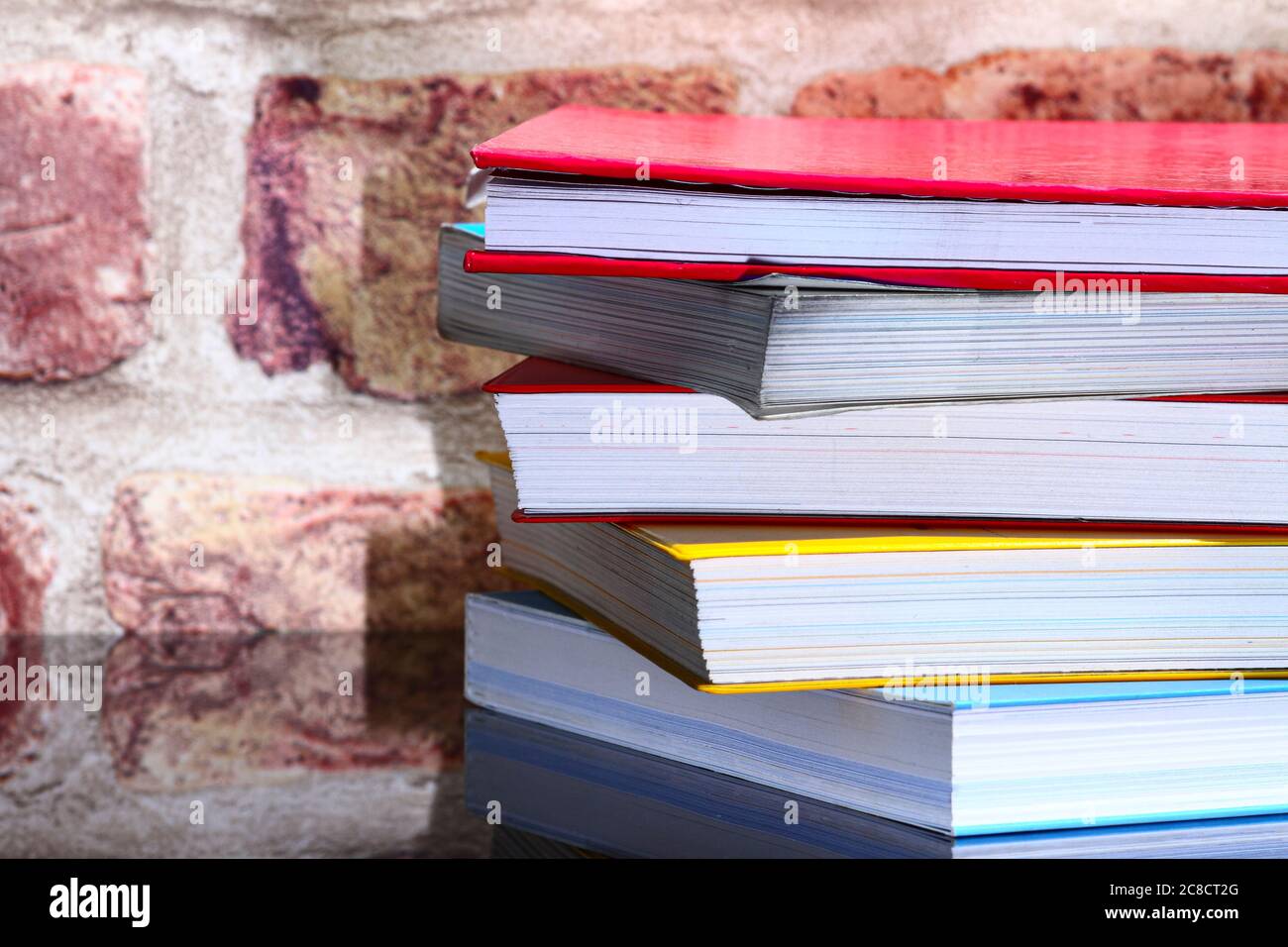 Stack of reading books on a glass table Stock Photo - Alamy