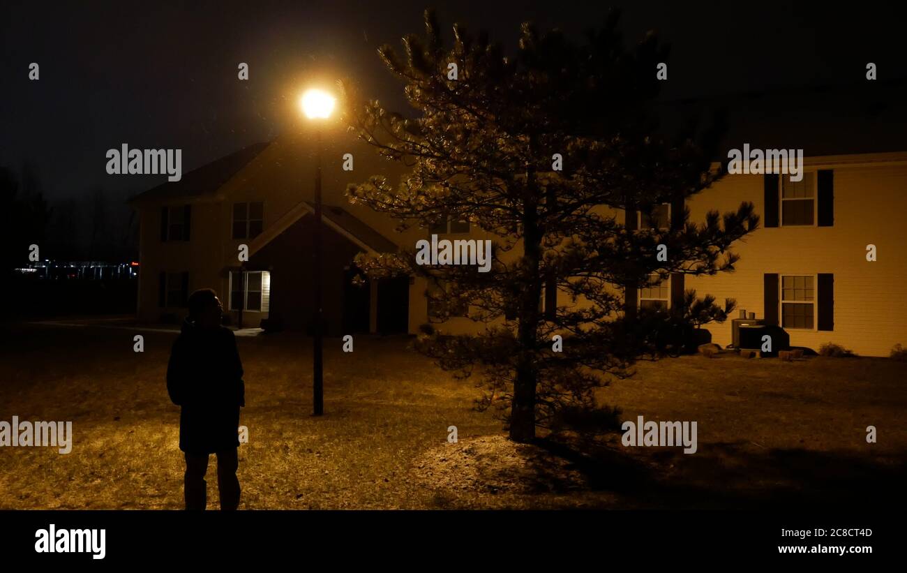 Man standing under tree illuminated by street light Stock Photo - Alamy
