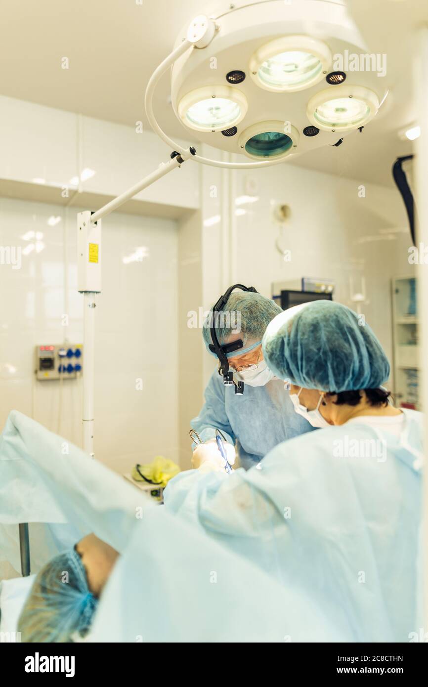 Surgery team operating in a surgical room Stock Photo - Alamy