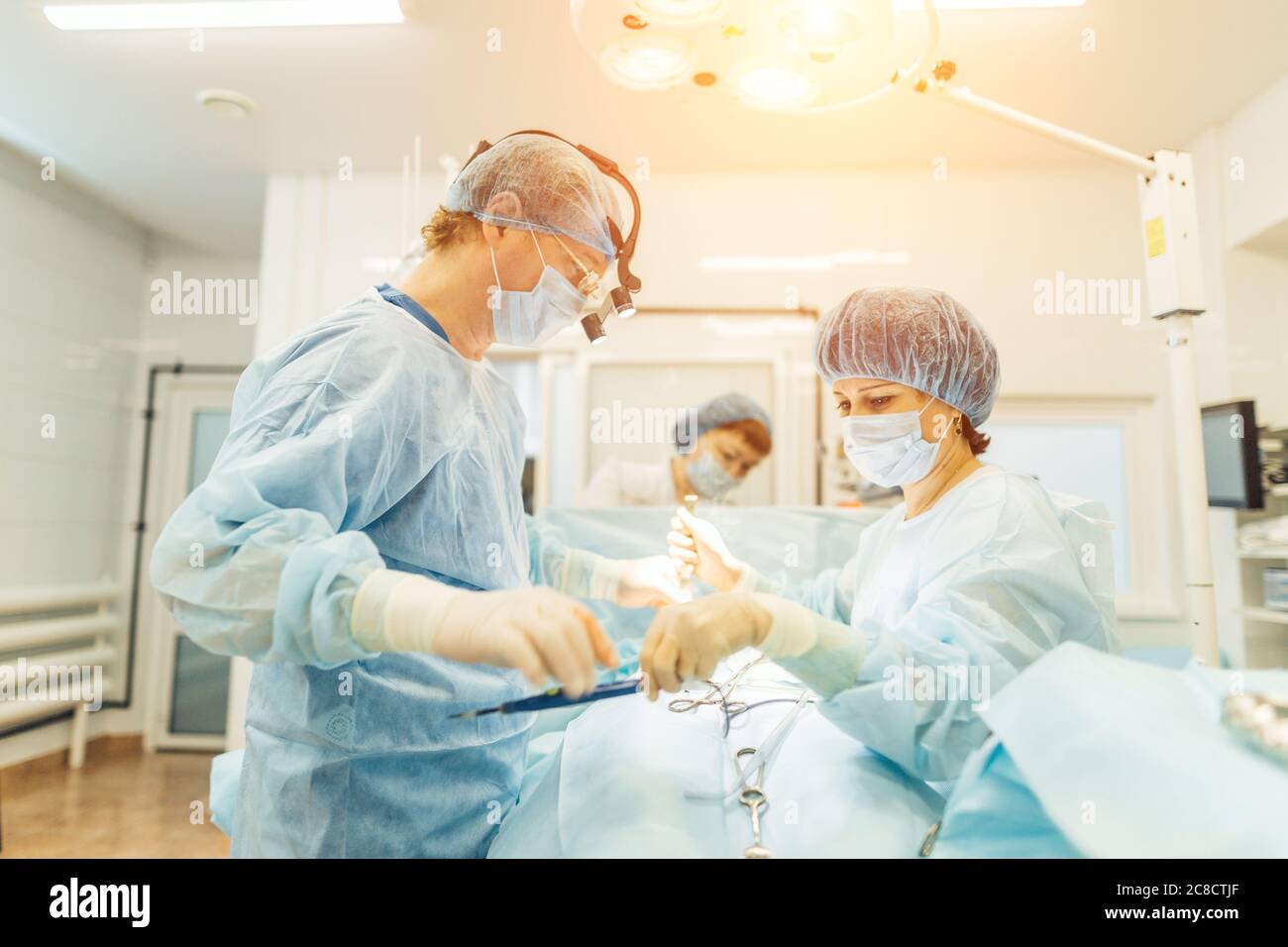 Surgeon taking scissors from the table Stock Photo - Alamy