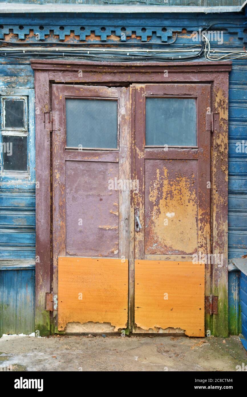 Curved rotten red old door to a village blue aged wooden house Stock ...