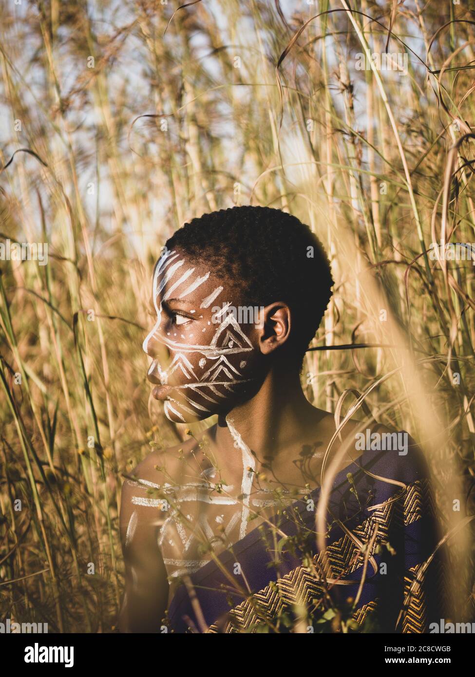 portrait of an african boy with ethnic face paint and dressing in the ...