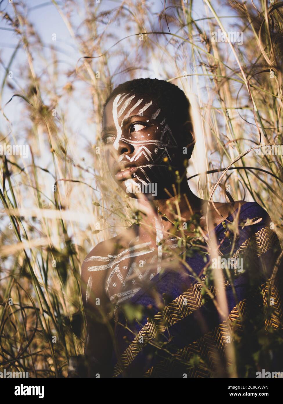 portrait of an african boy with ethnic face paint and dressing in the ...