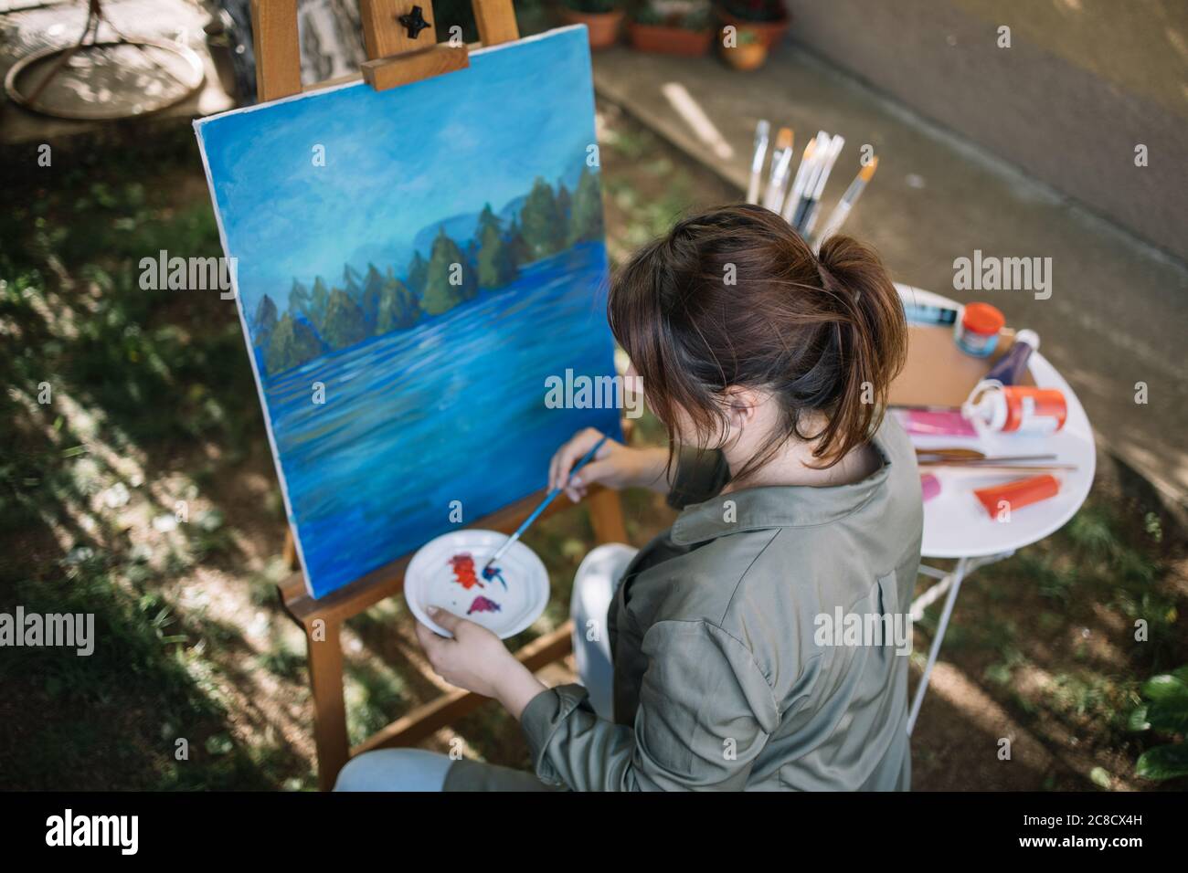 Back view of female painter drawing picture in backyard Stock Photo - Alamy