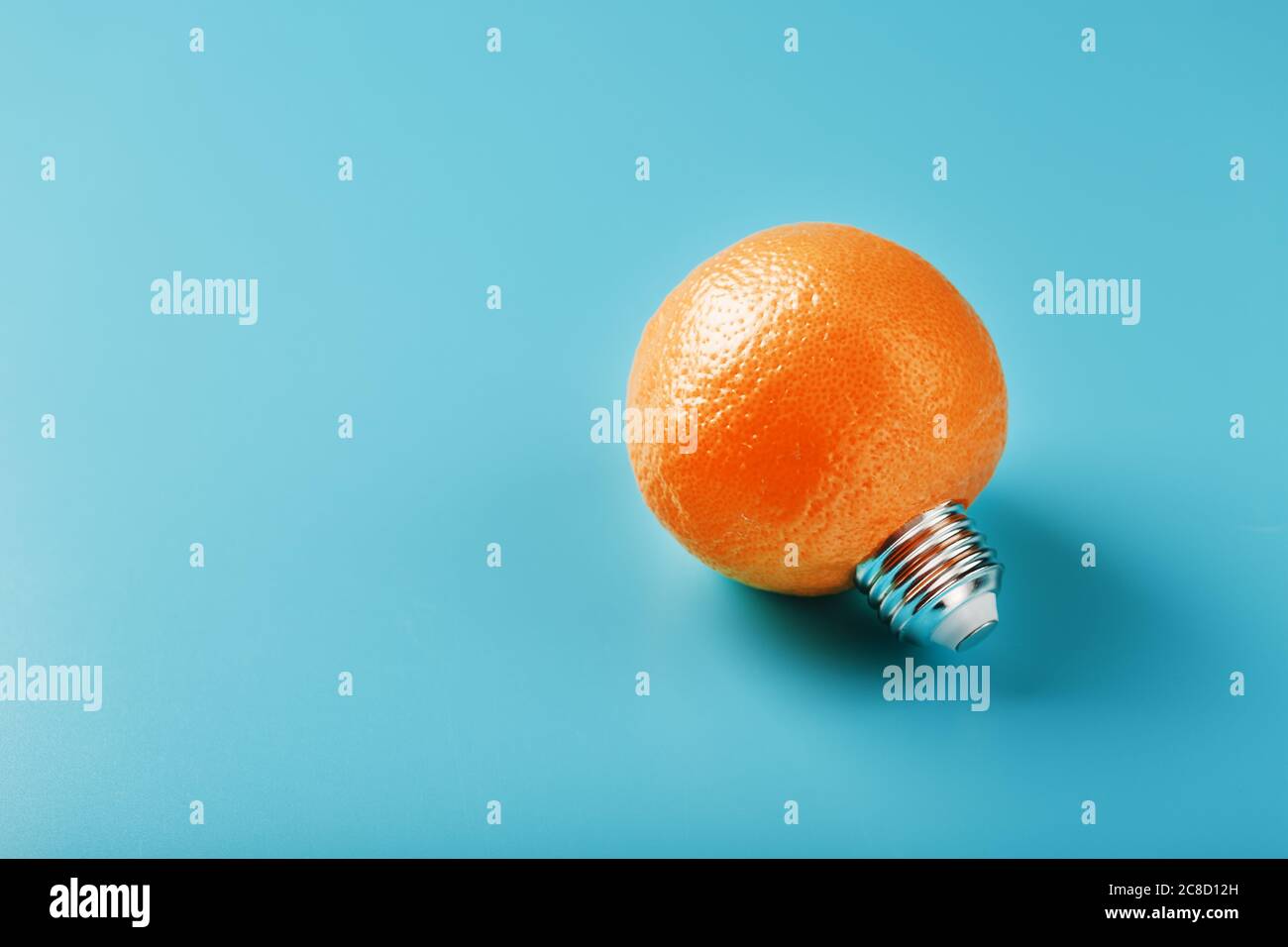 Orange light bulb on a blue background. The concept of fruit ideas ...