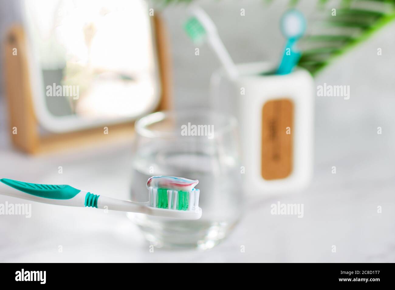 Toothbrush with toothpaste in the bathroom table with glass of water ...