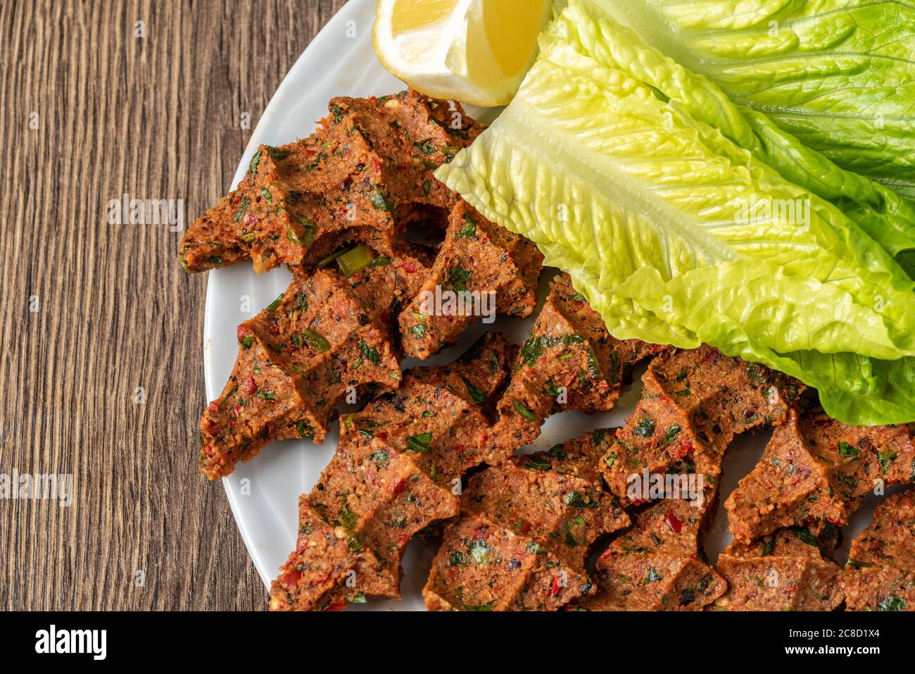 Cig kofte (raw meatball in Turkish) with lettuce and lemon. Turkish ...