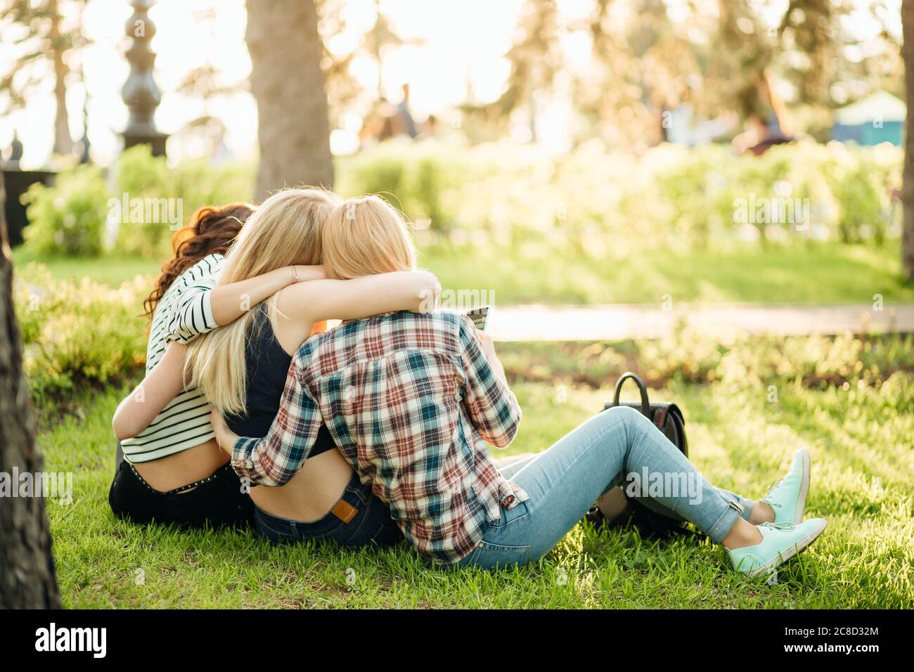 three girls having fun in the sunset park. rear view Stock Photo - Alamy