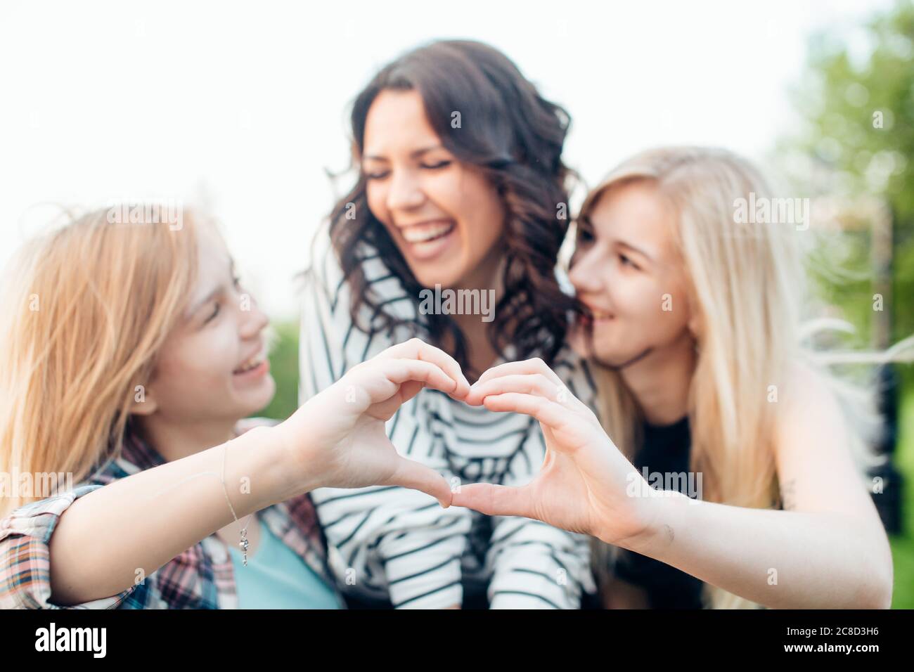 three female friends making heart shape from hand Stock Photo - Alamy