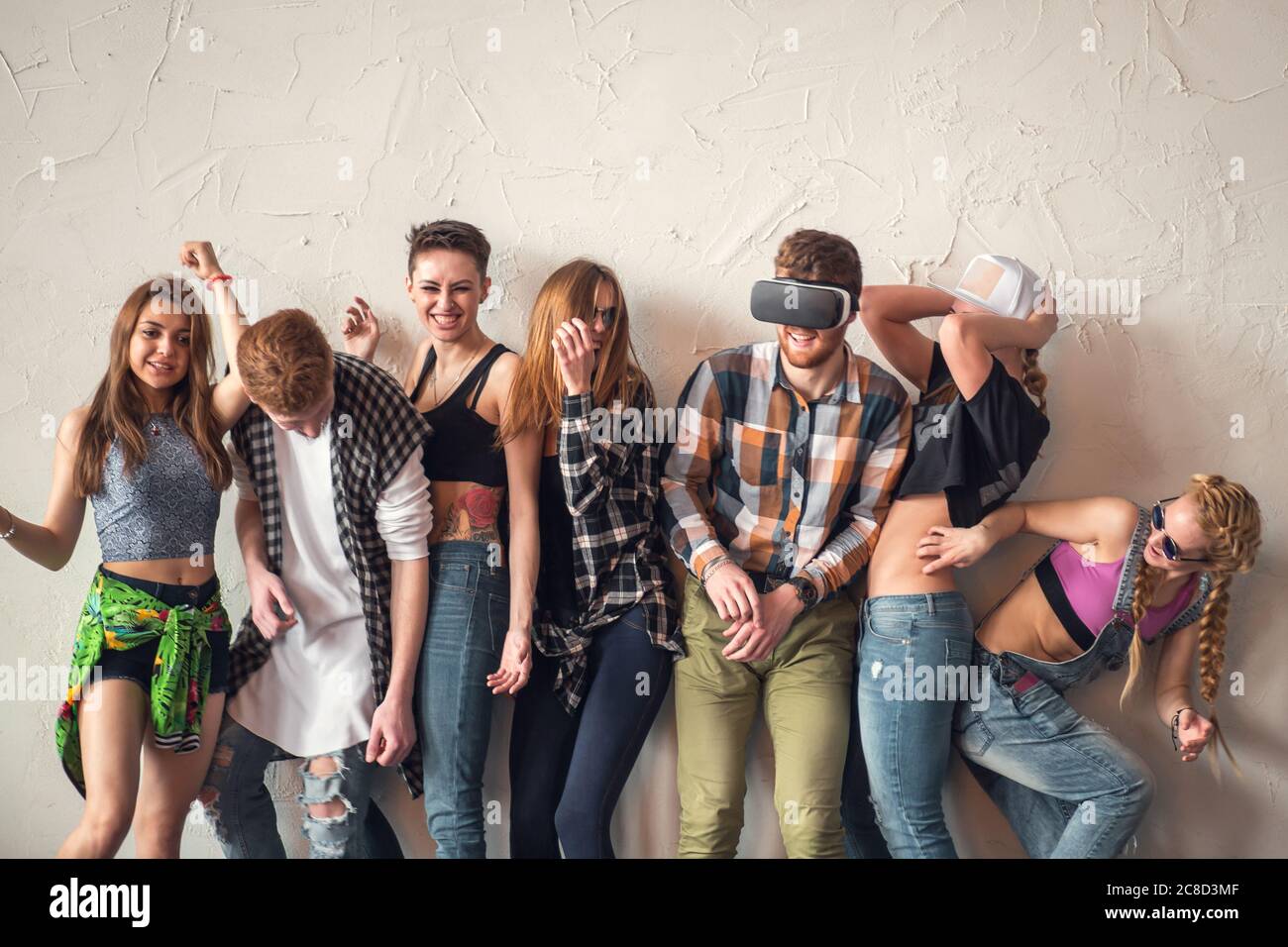 Group of seven friends laughing out loud indoor, sharing good and ...