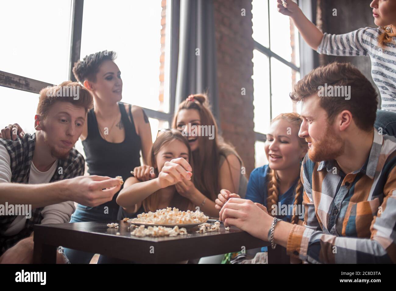Attractive young people throwing popcorn and enjoying together Stock ...