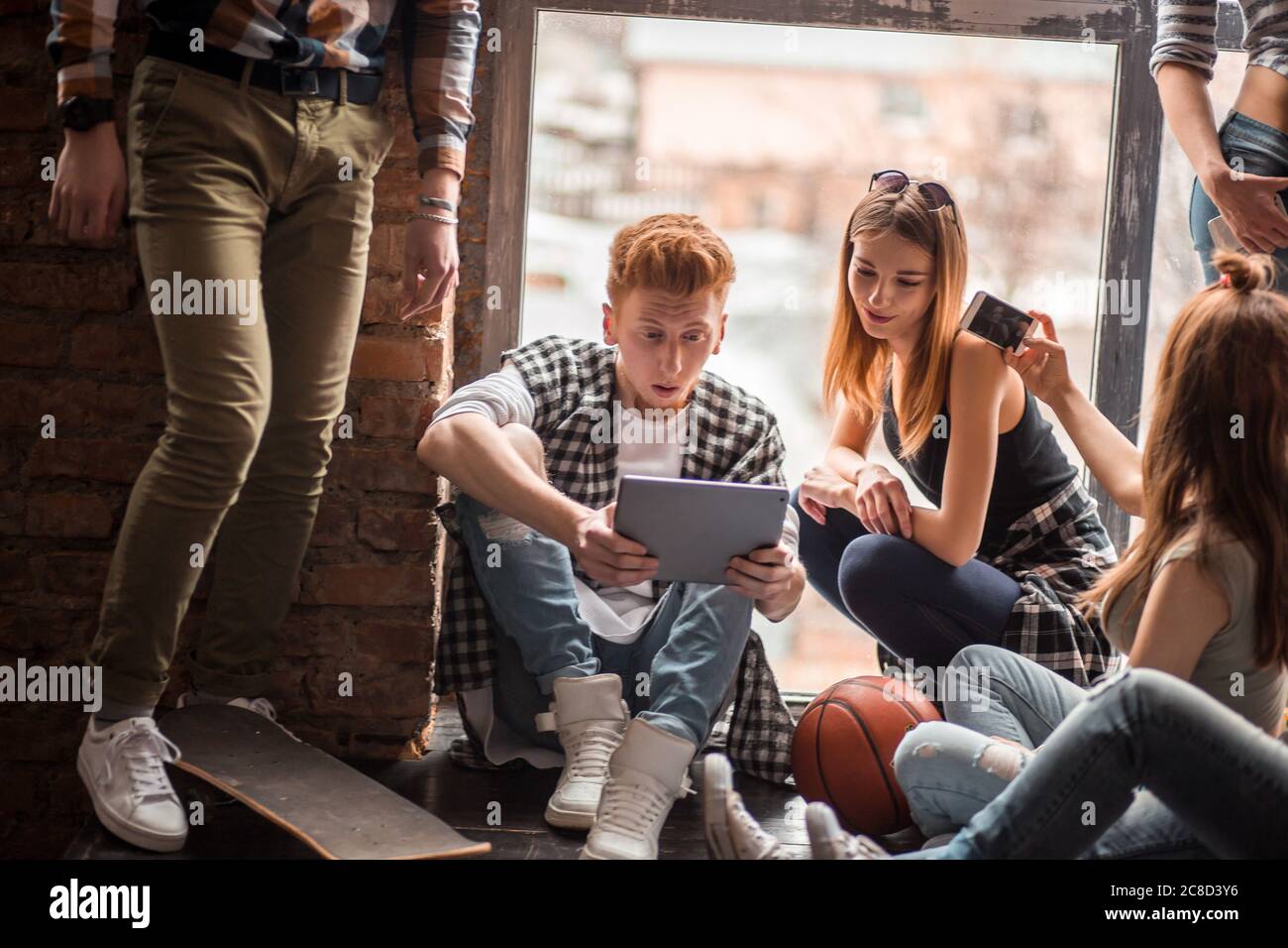 group of friends using cellphones - Students sitting in a row and ...