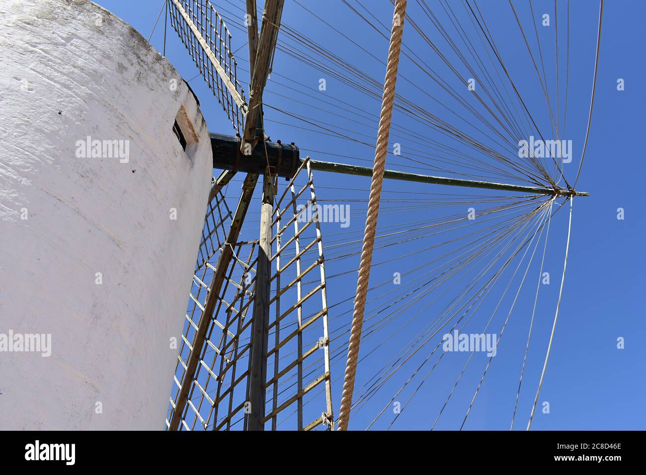 Old fashioned windmill with wood wind sails against deep blue sky in ...