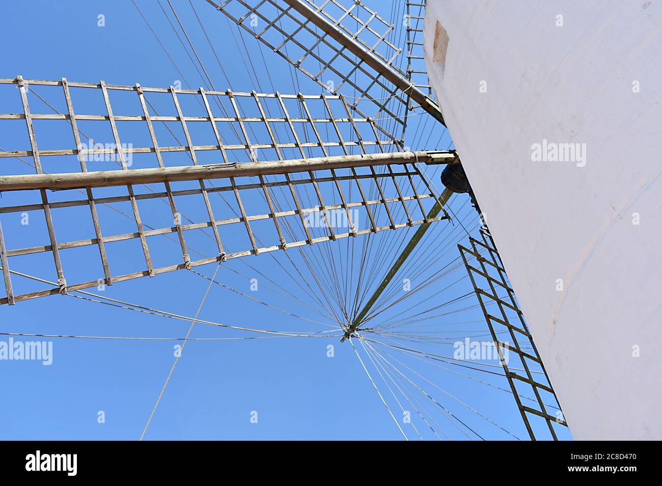 Old fashioned windmill with wood wind sails against deep blue sky in ...