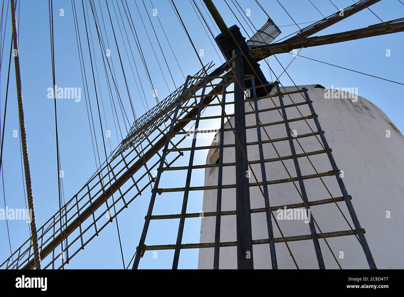 Old fashioned windmill with wood wind sails against deep blue sky in ...
