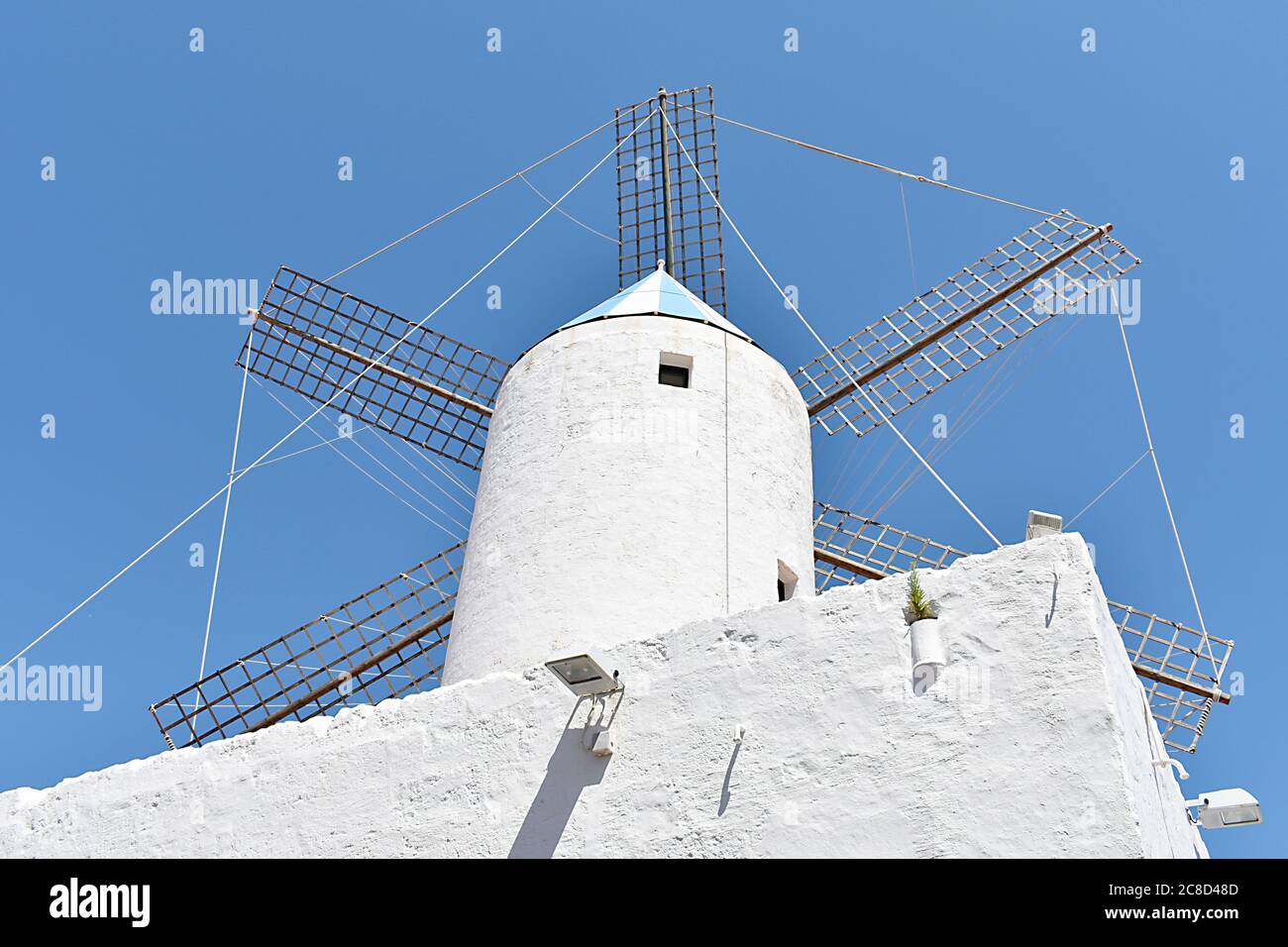 Old fashioned windmill with wood wind sails against deep blue sky in ...