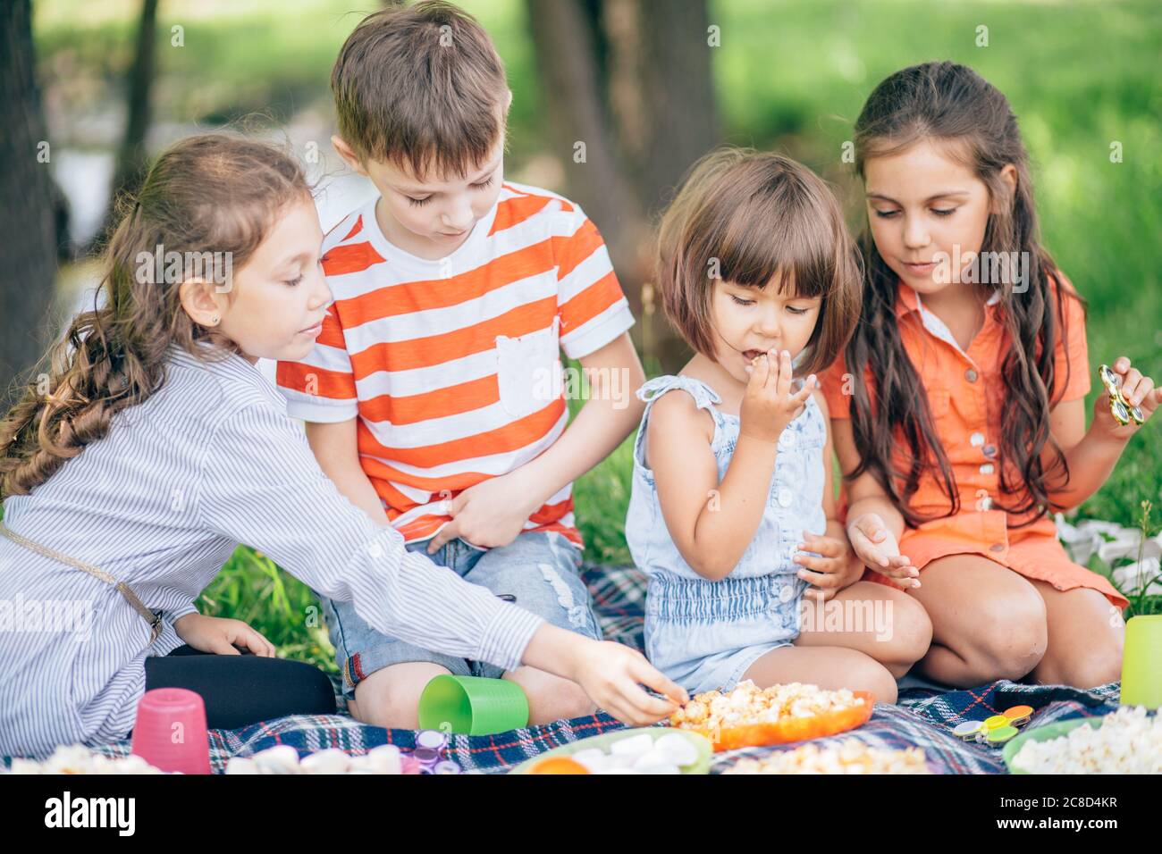 Little children eating lunch outdoors. Kids with picnic basket in ...