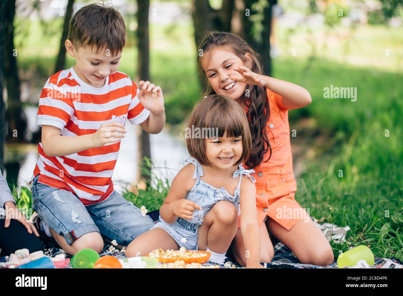 Portrait of three Children having fun in the garden in summer. They are ...